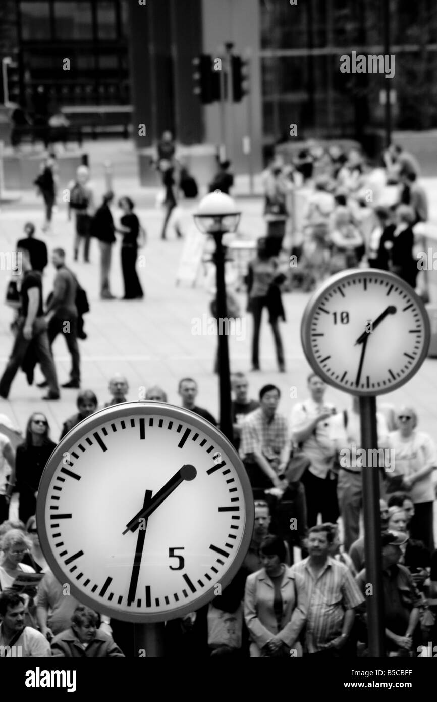 Clocks and a crowd in Docklands Stock Photo - Alamy