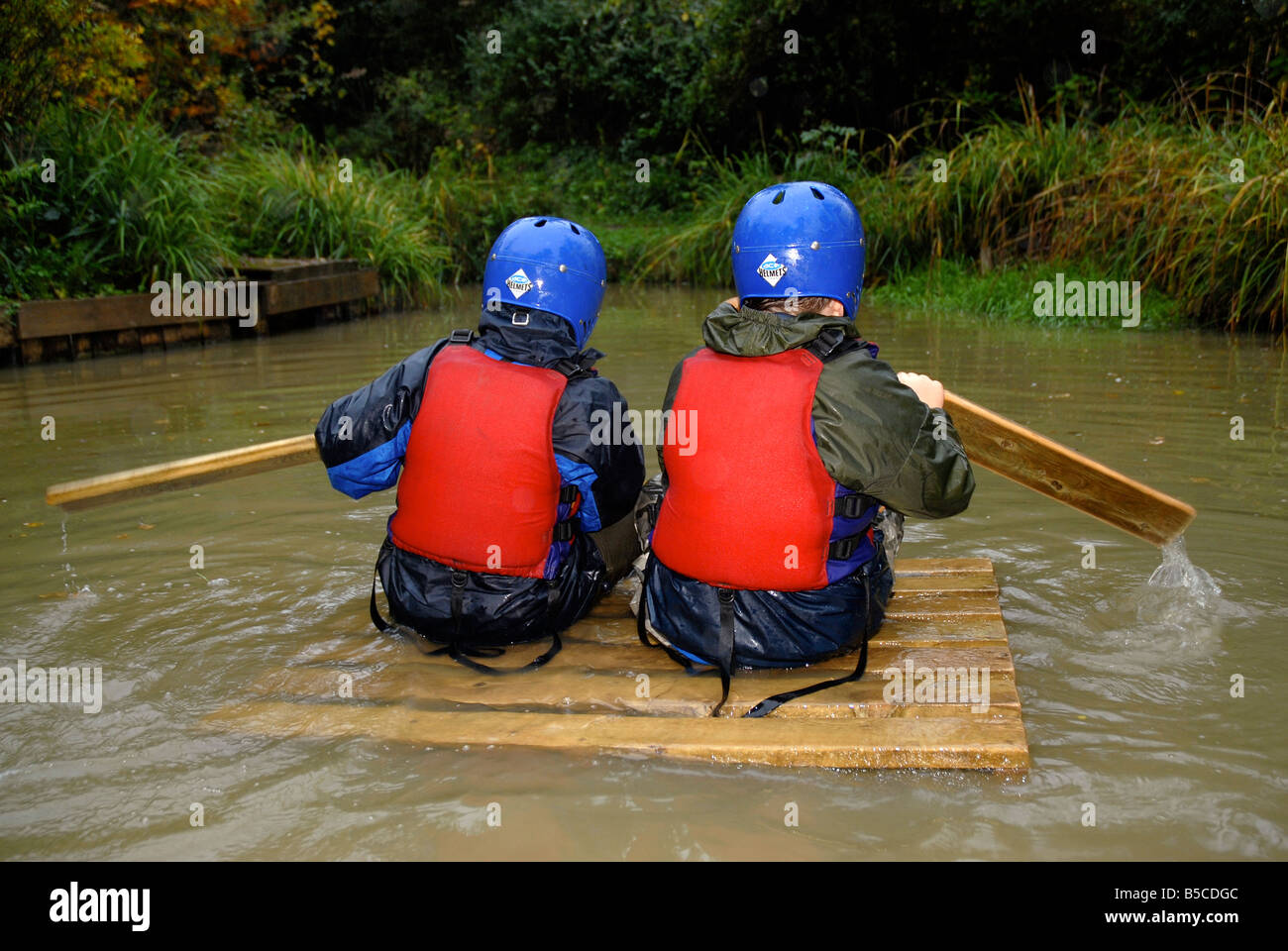 Two boys rafting in lake Stock Photo - Alamy