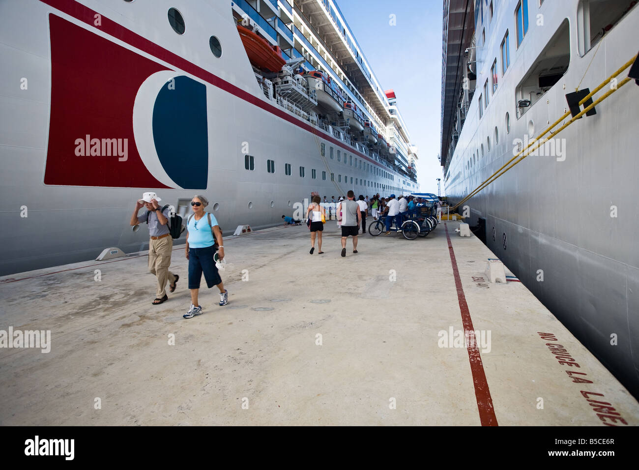 Two cruise ships separated by a concrete dock Stock Photo - Alamy