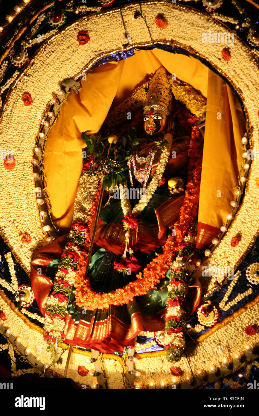 A float showing a Hindu deity is paraded through the streets of Ulsoor ...