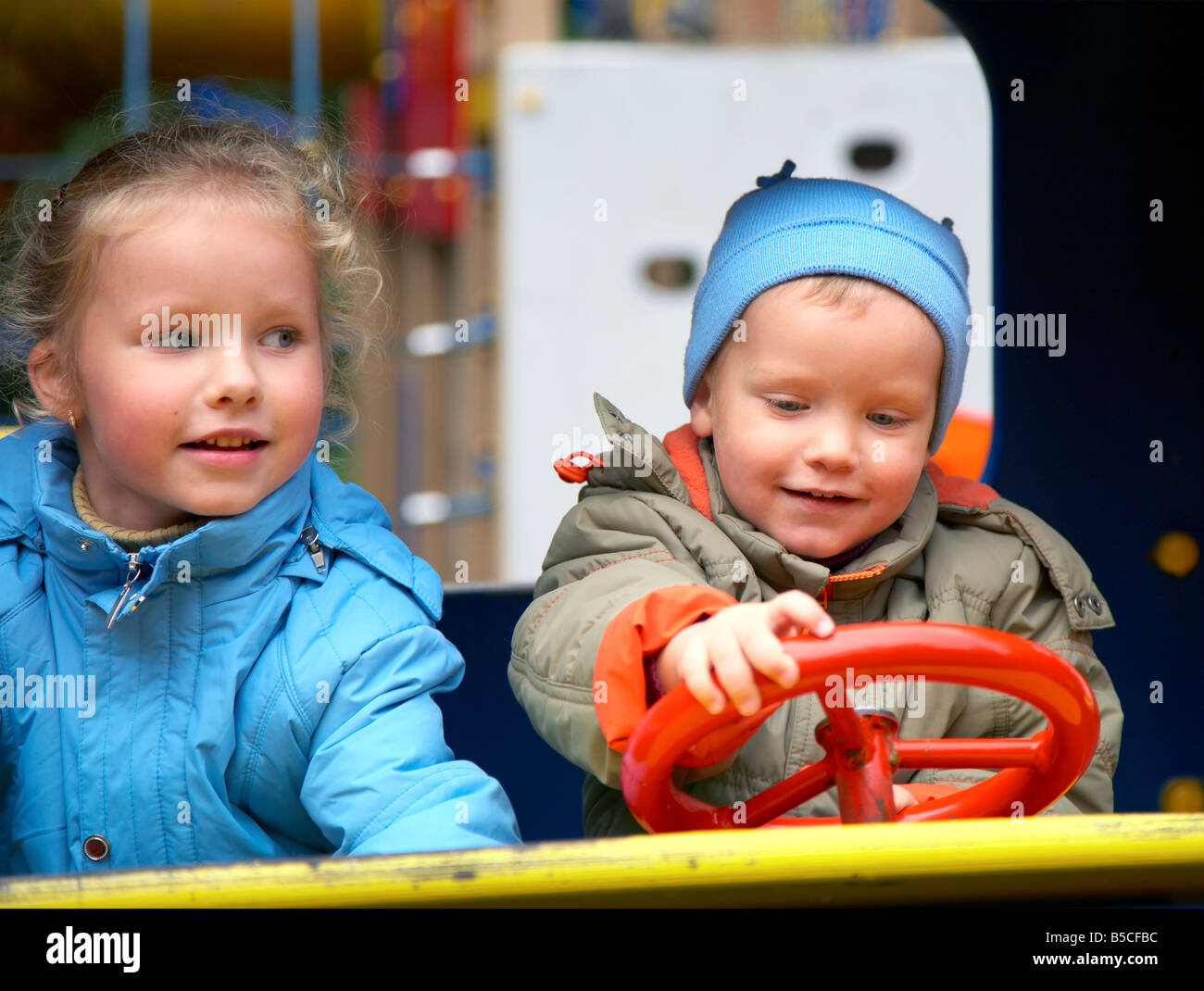 Little boy is learning to drive on the pleasure-ground and his sister ...
