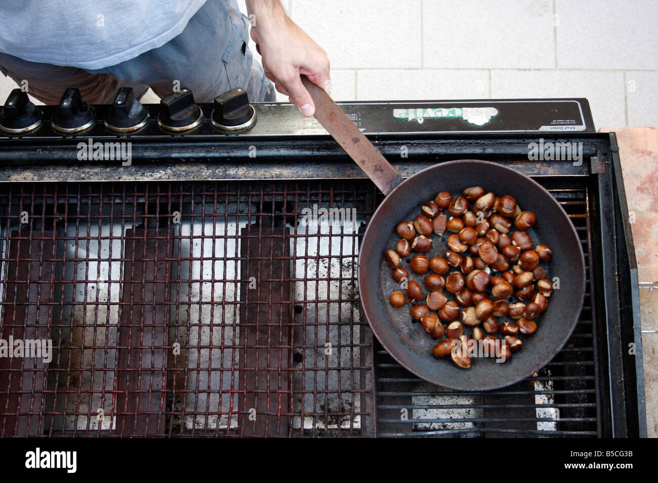 In autumn man cooking roast chestnut in the outdoor barbecue Stock ...