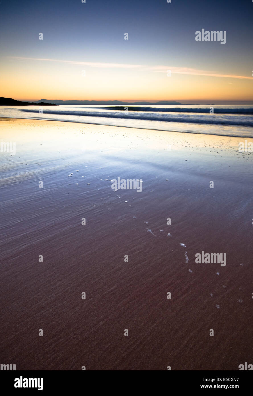 Patterns in the sand are revealed as the ride recedes and dusk falls on ...