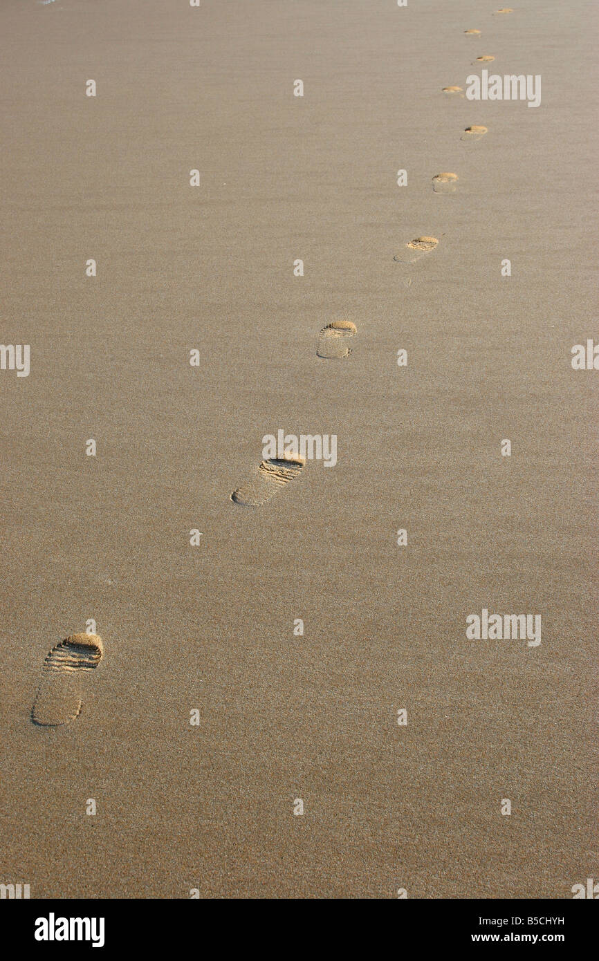 Diagonal line footsteps on the sand Stock Photo - Alamy