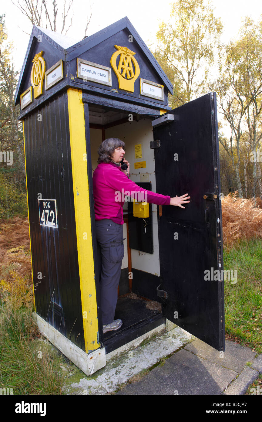 Woman opening door to AA phone to make a call box Scotland UK Stock ...