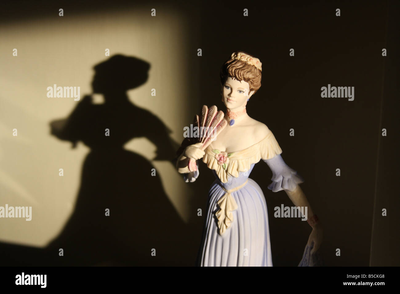 Strong shadow on wall from porcelain figure of lady in room decoration ...