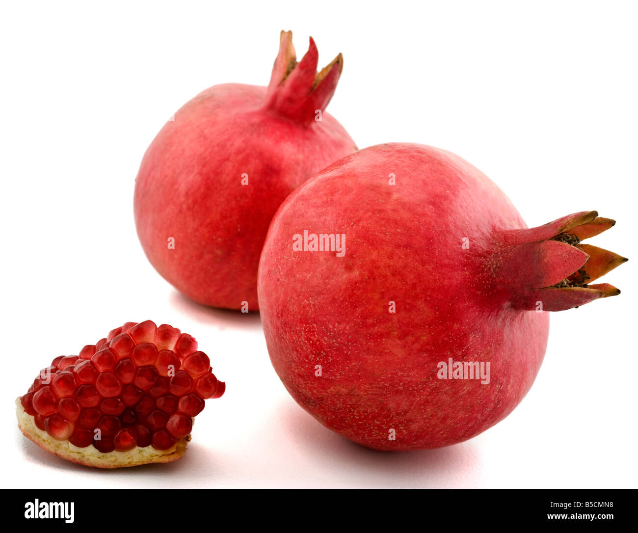 two pomegranates and slice of pomegranate isolated on white Stock Photo ...