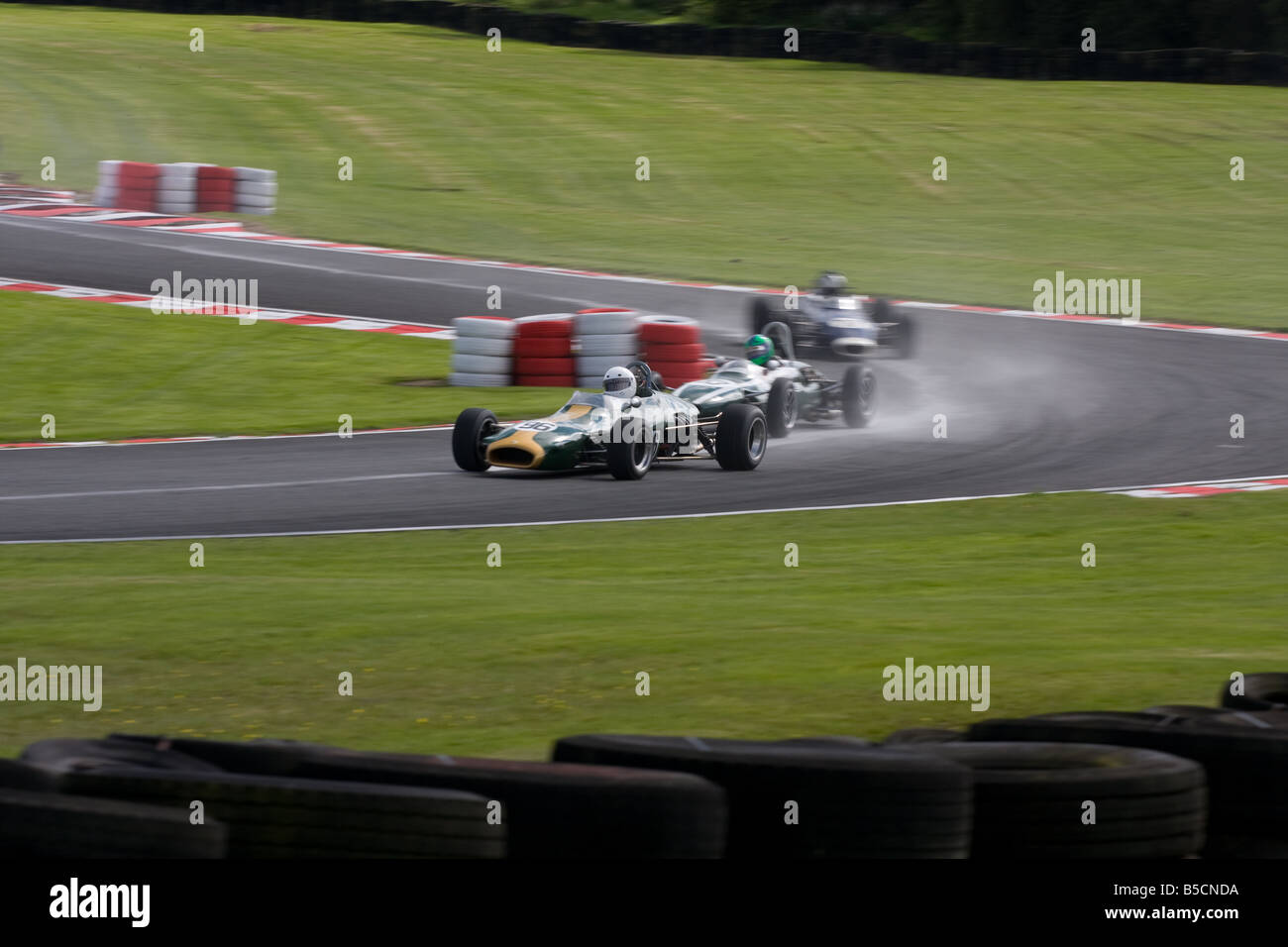 A very slow shutter speed shot of three classic cars that are racing ...