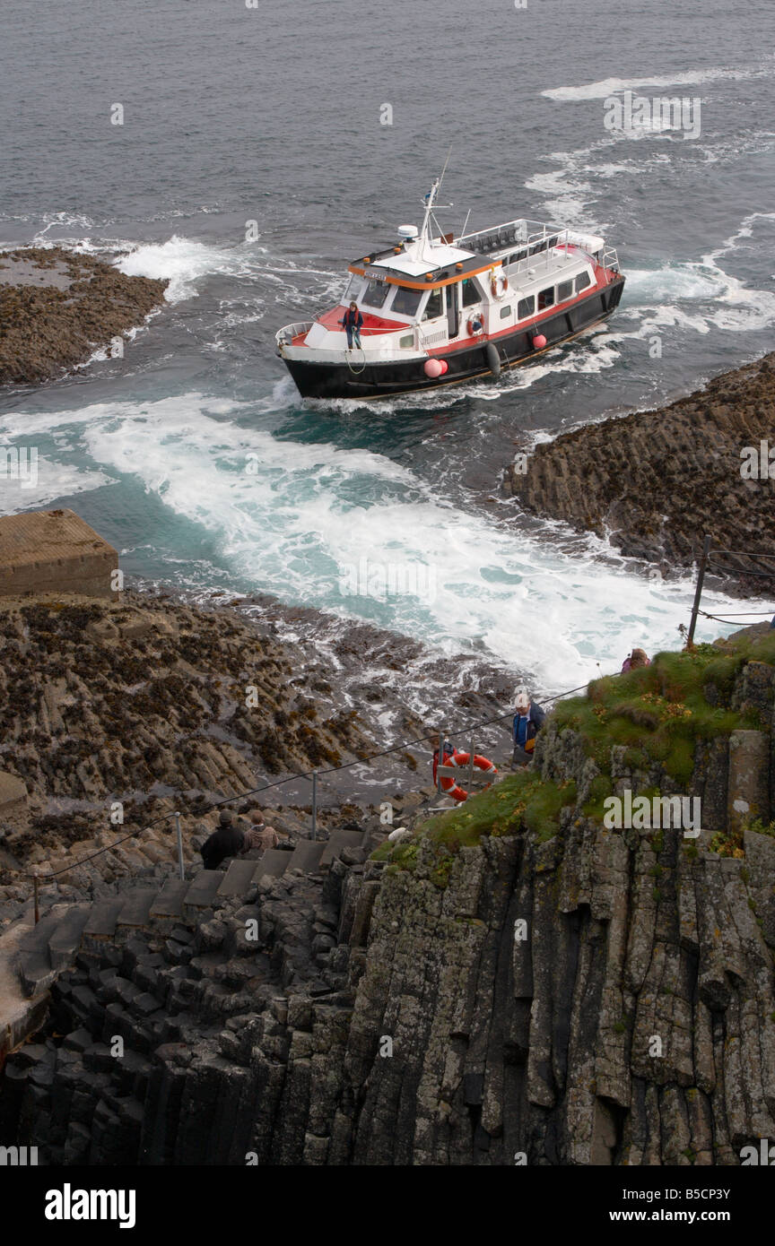 tourist pleasure boat coming in to land at the stone jetty on the ...