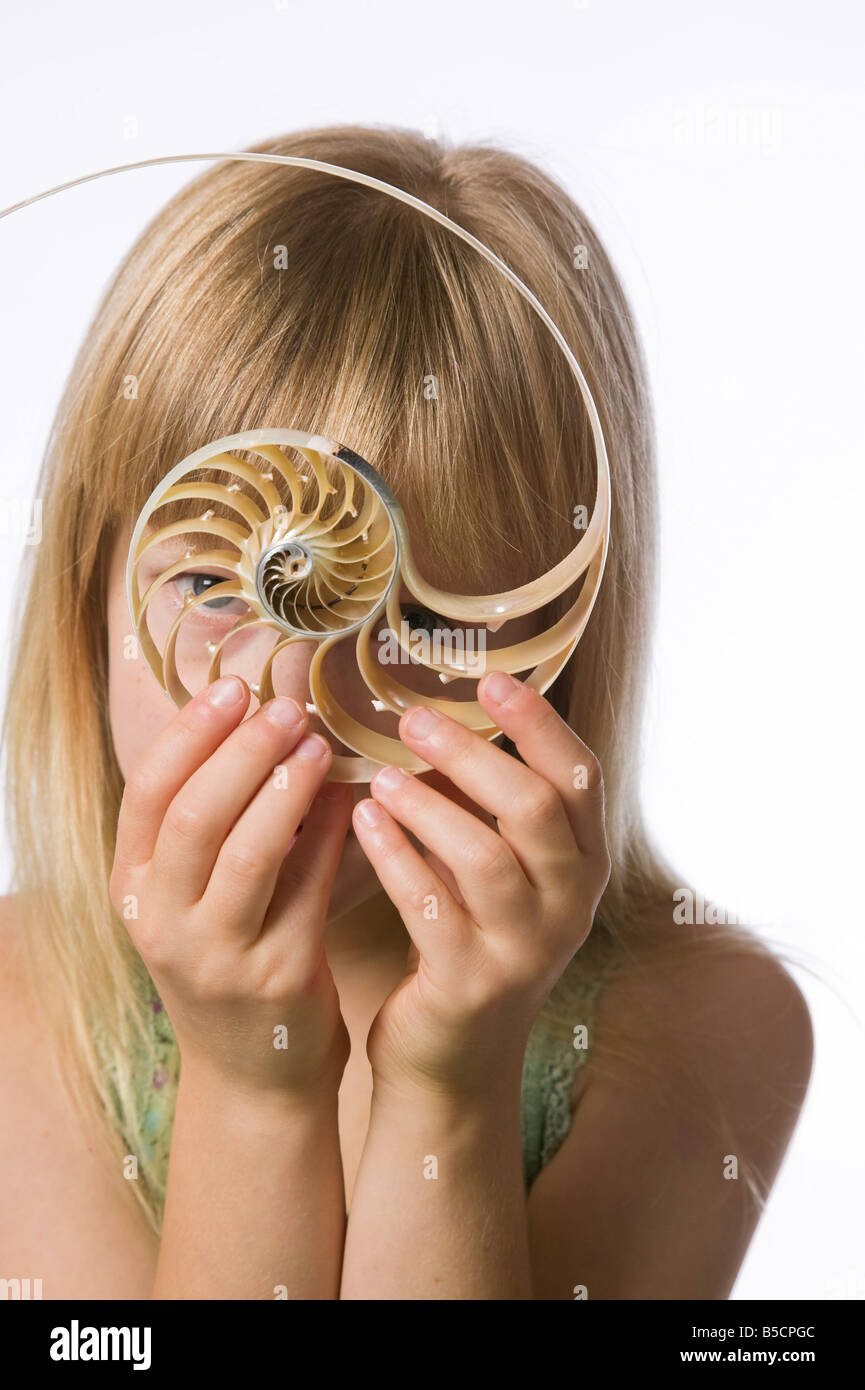 Girl holding nautilus shell in front of her face Stock Photo - Alamy