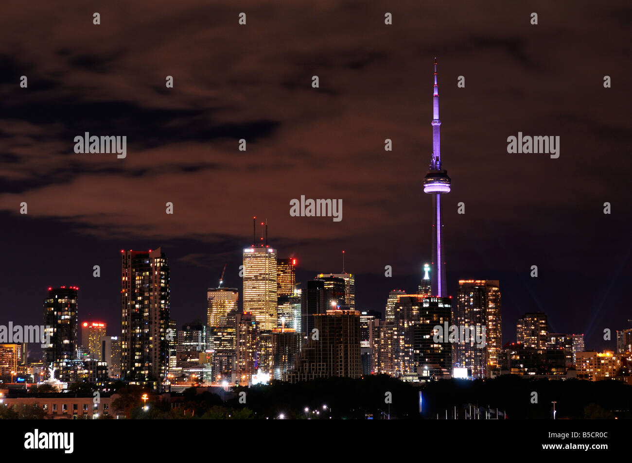 Cityscape of Toronto at night with colored CN Tower and highrise tower ...