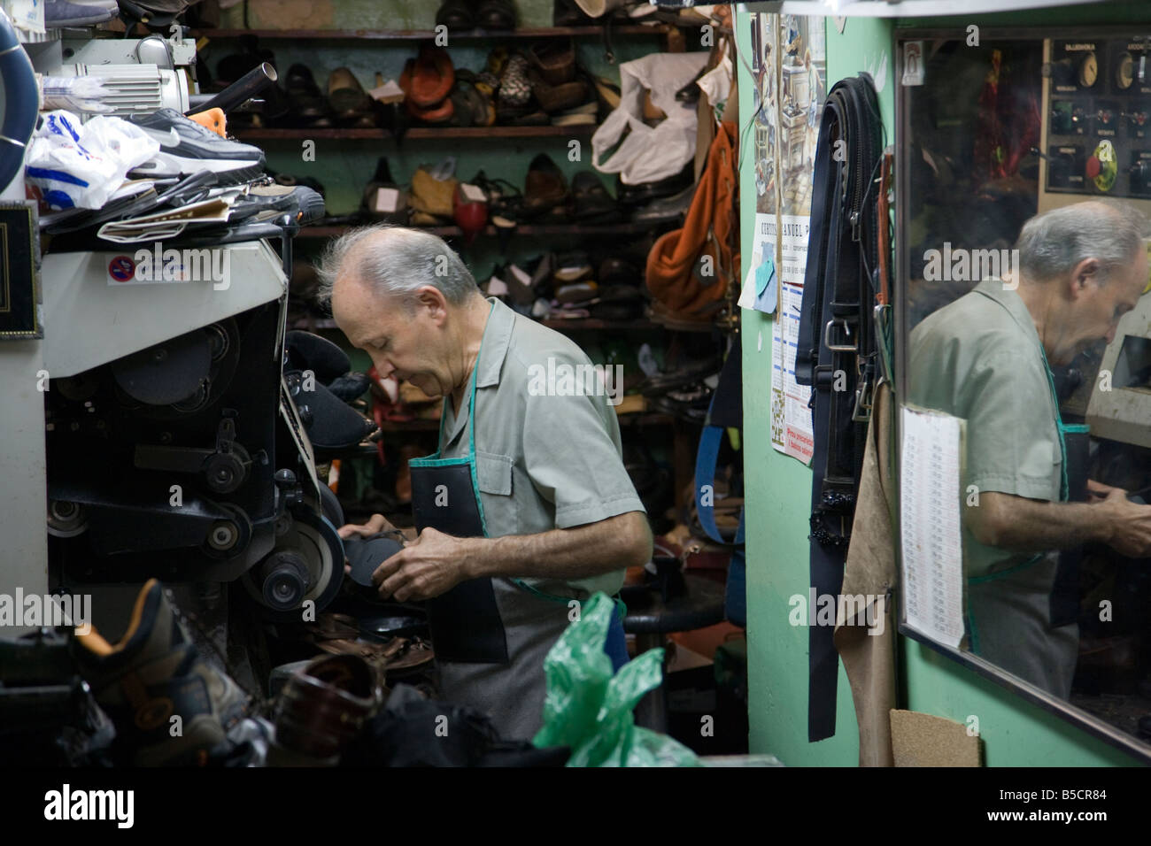 Busy cobbler, shoe repairer, working away in a side street in Barri ...
