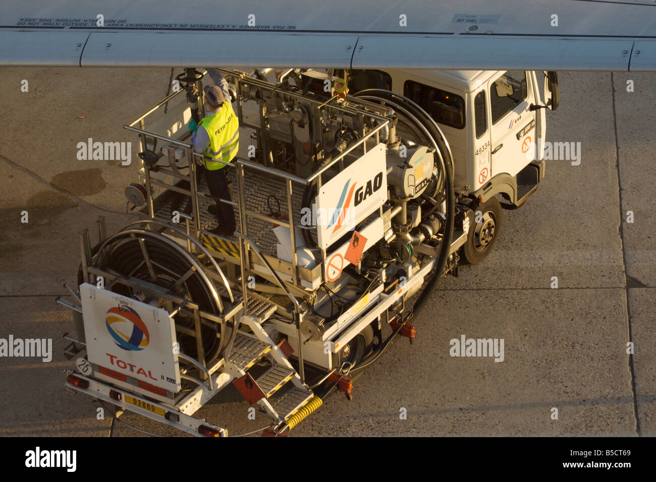 Airport worker refuellling commercial aircraft. Ground support ...