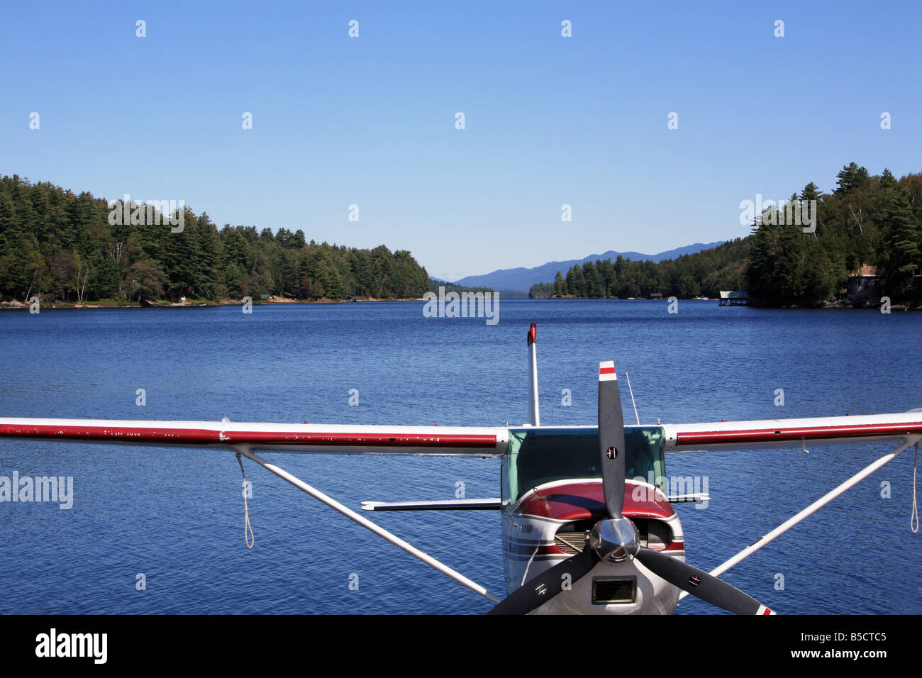 A single engine float plane tied to the dock on Long Lake New York ...