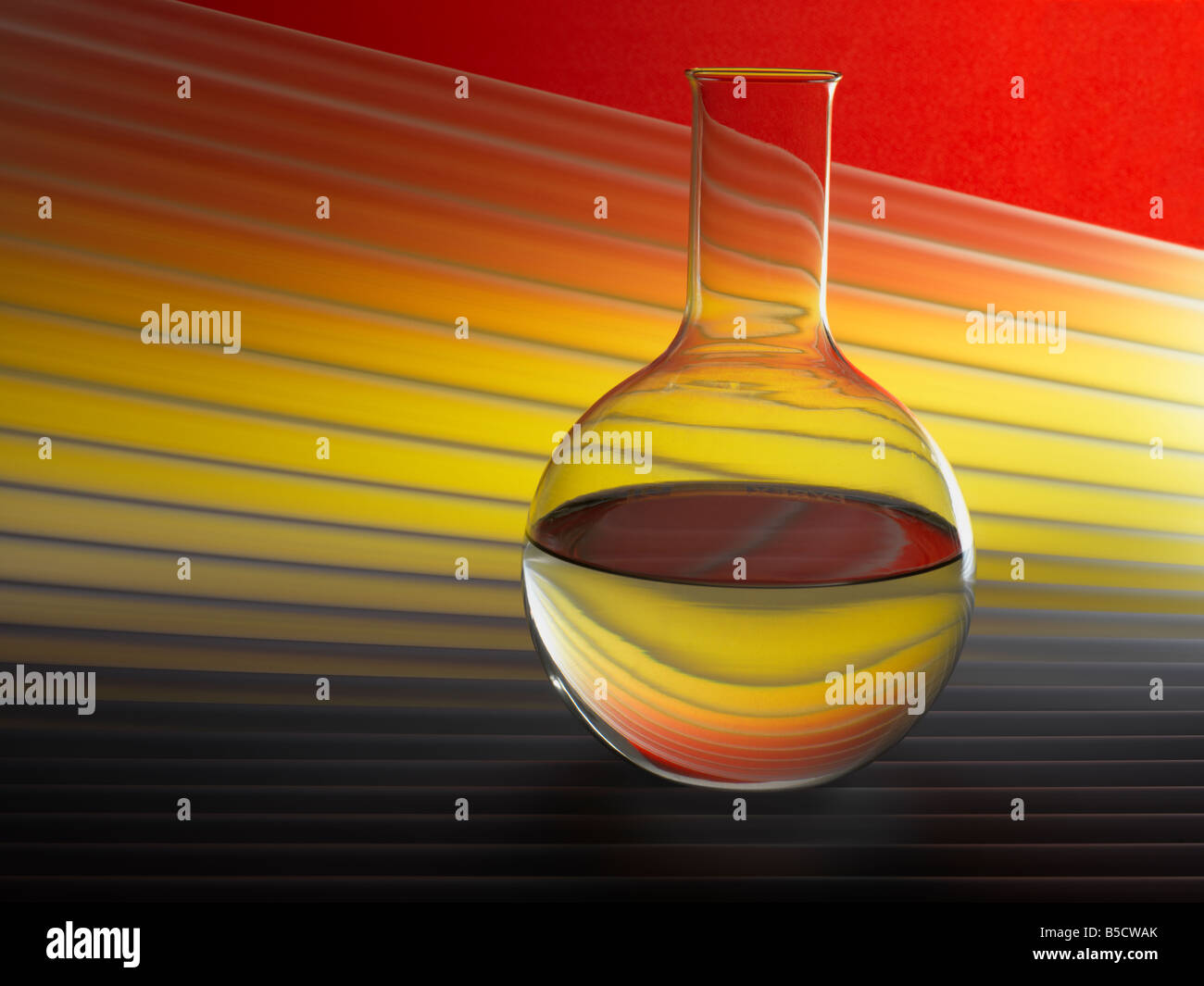 laboratory flask on coloured surface Stock Photo - Alamy