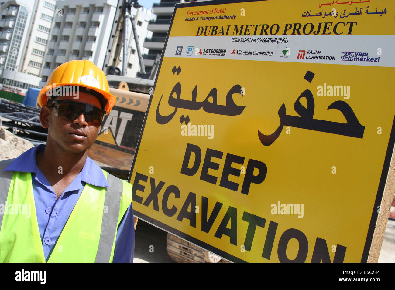 Worker yellow hard hat deep excavation site sign Stock Photo - Alamy