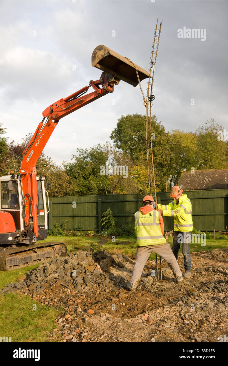 Workmen inserting steel reinforcement bars into concrete piles Stock ...