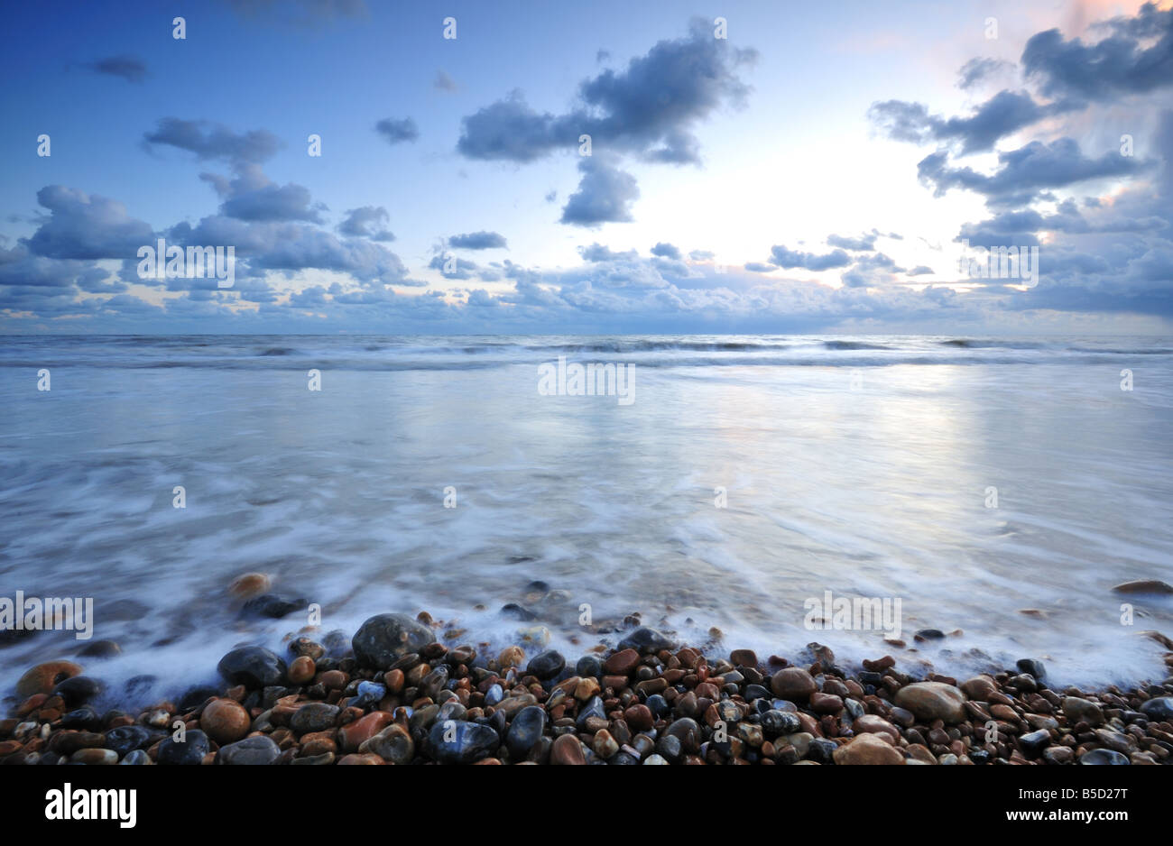 Brighton and Hove beach with pebbles and stones, stormy clouds at dusk ...