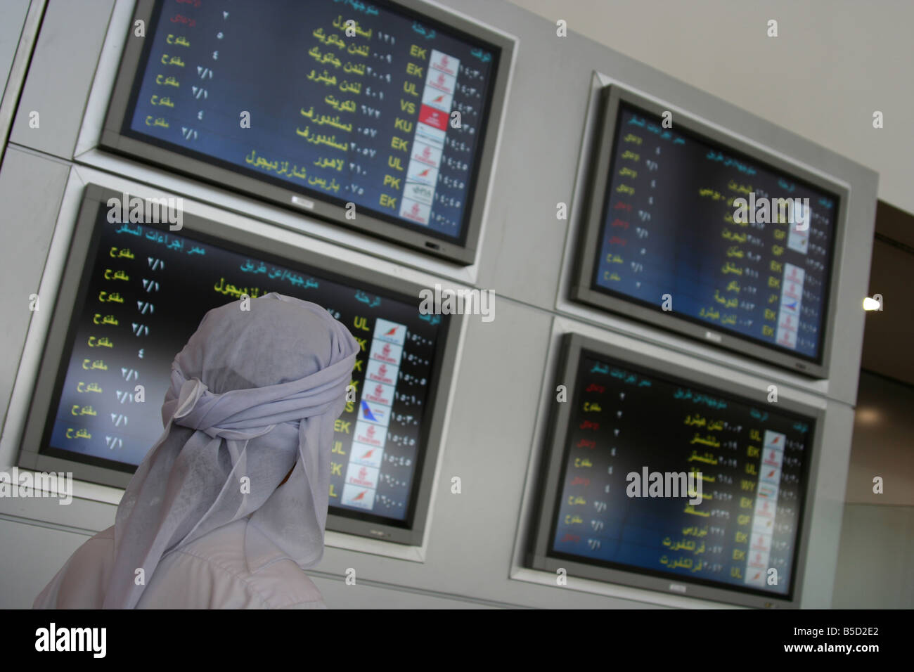 passenger checking flight information screen monitor dubai airport uae ...
