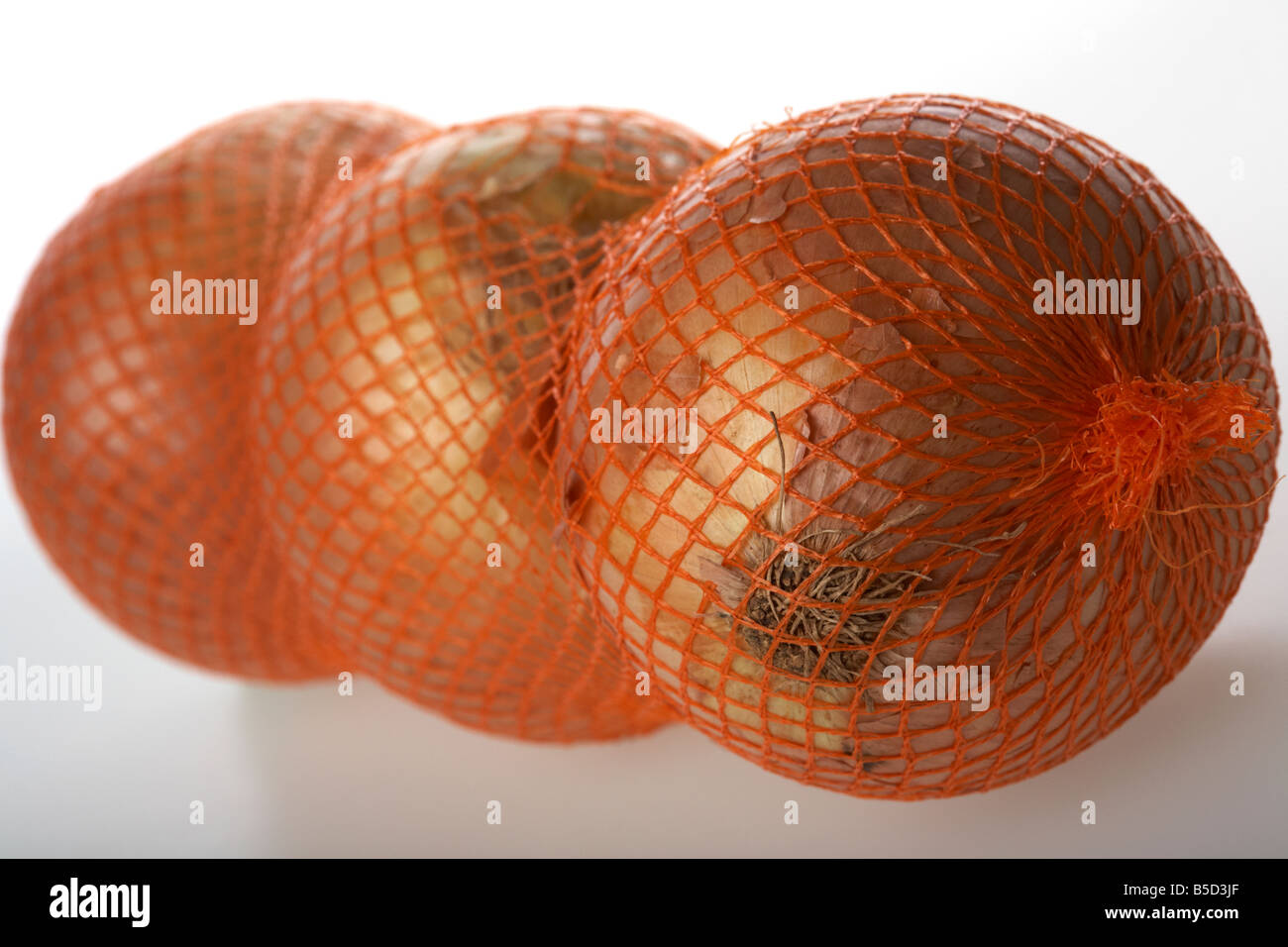 three large spanish onions in net packaging Stock Photo - Alamy