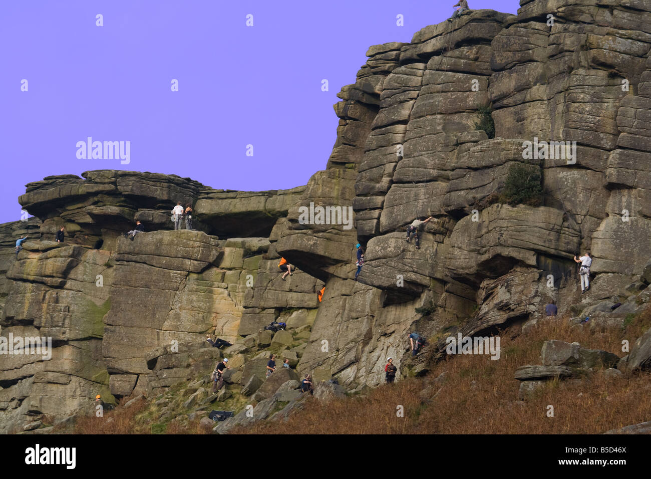 Climbers climbing cliff face Stock Photo - Alamy