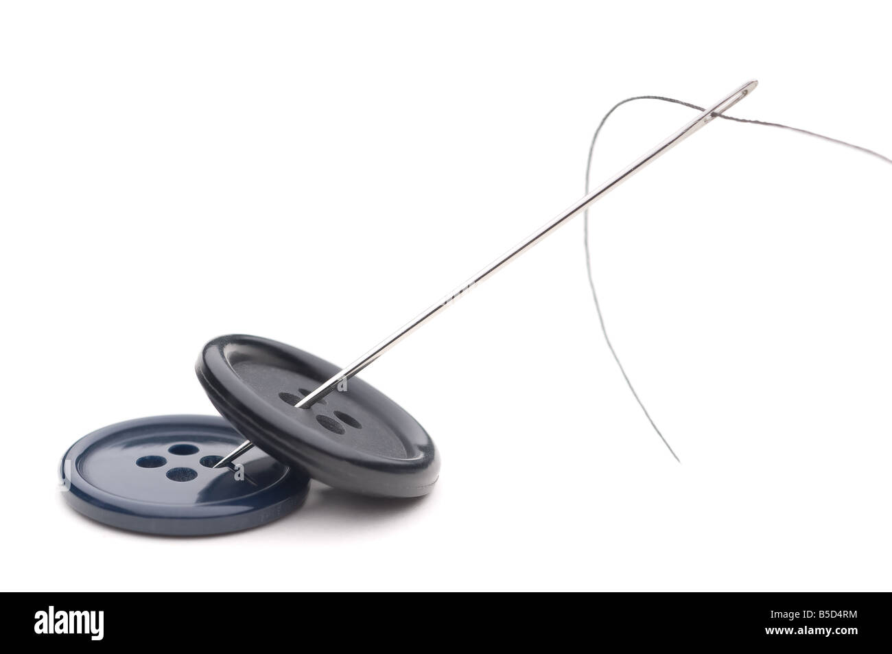 Macro of a needle and buttons Stock Photo - Alamy