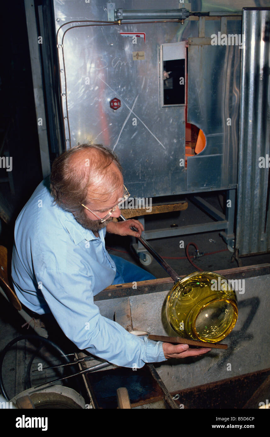 Man shaping cooling molten crystal glass into bowl shape, Orrefors ...