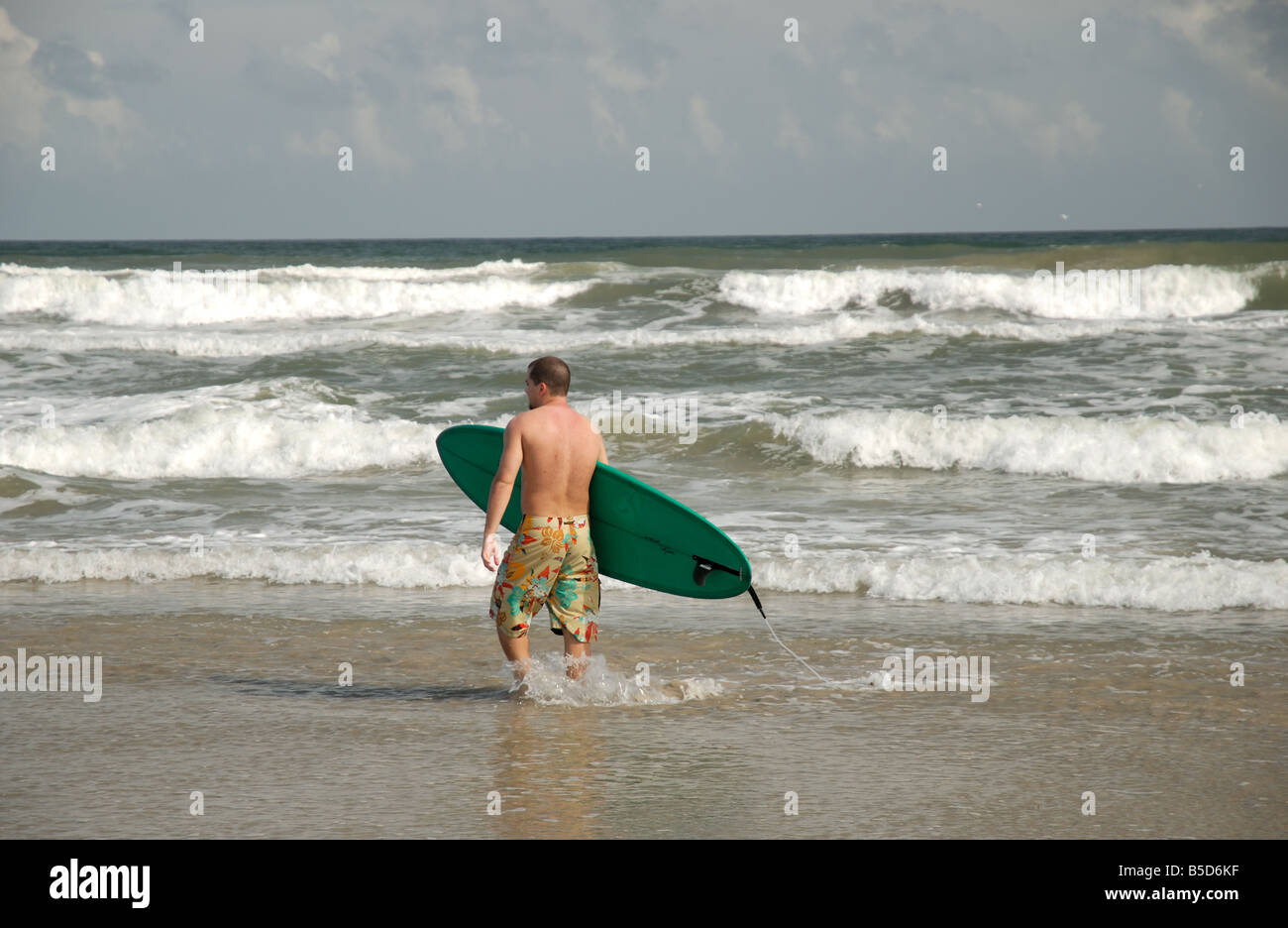 Surfer walking on the ocean beach Stock Photo - Alamy