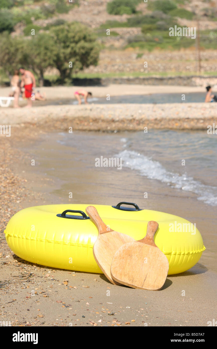 yellow inflatable by the sea and wooden beach tennis rackets with ...