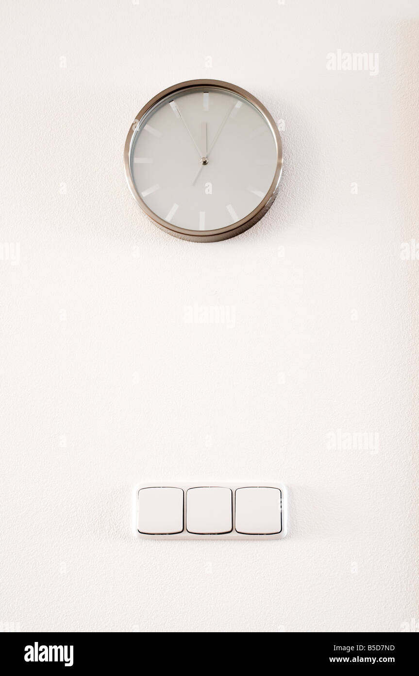 Clock on the wall with three switch buttons Stock Photo - Alamy