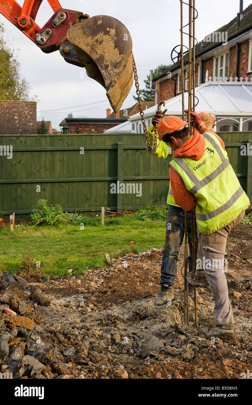 Workmen inserting steel reinforcement bars into concrete piles Stock ...