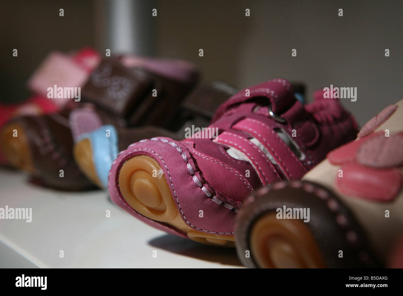 some children's shoes lined up on a shelf next to each other Stock ...