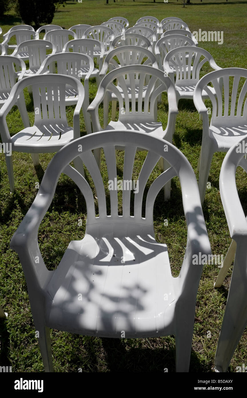 line up of white chairs in garden setting Stock Photo - Alamy