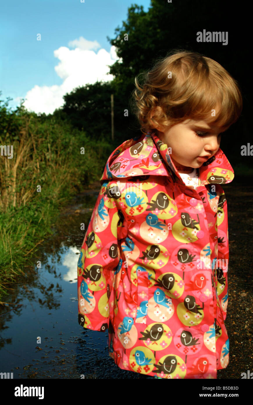 Little girl wading through a huge puddle in the countryside Stock Photo ...