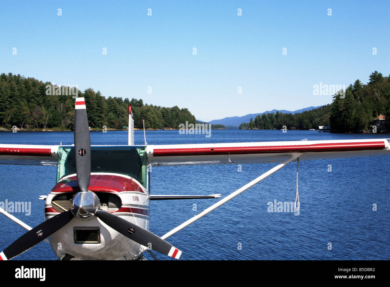 A single engine float plane tied to the dock on Long Lake New York ...