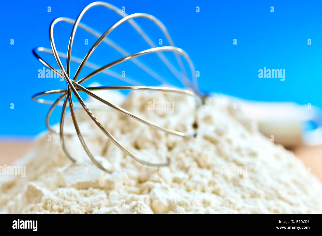 Flour and whisk on kitchen board close up Stock Photo - Alamy