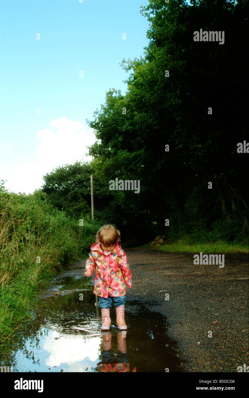 Little girl wading through a huge puddle in the countryside Stock Photo ...