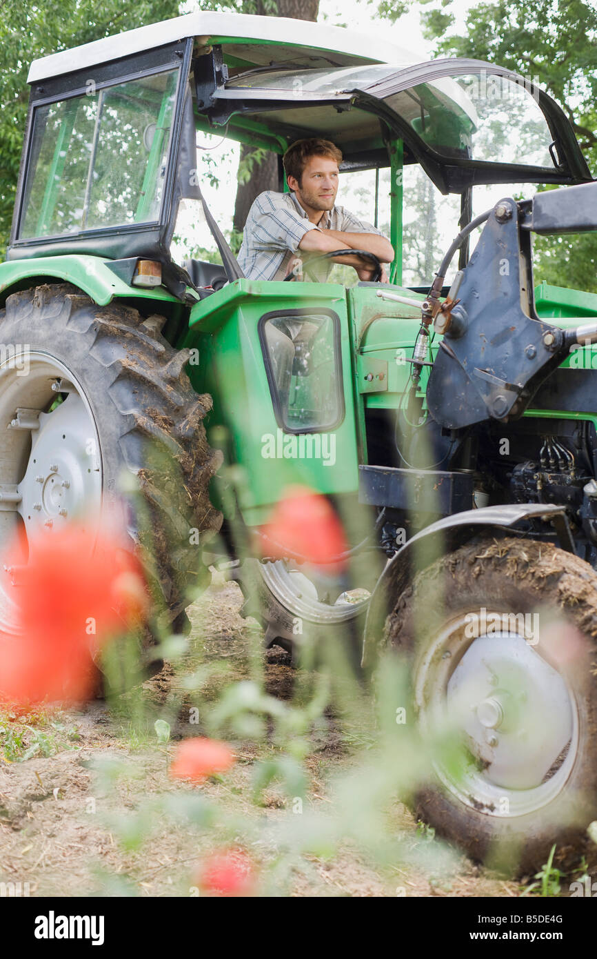 Farmer sitting on tractor Stock Photo - Alamy