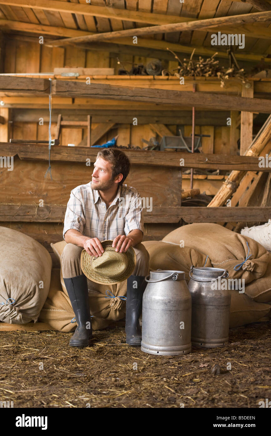 Farmer sitting in barn Stock Photo - Alamy