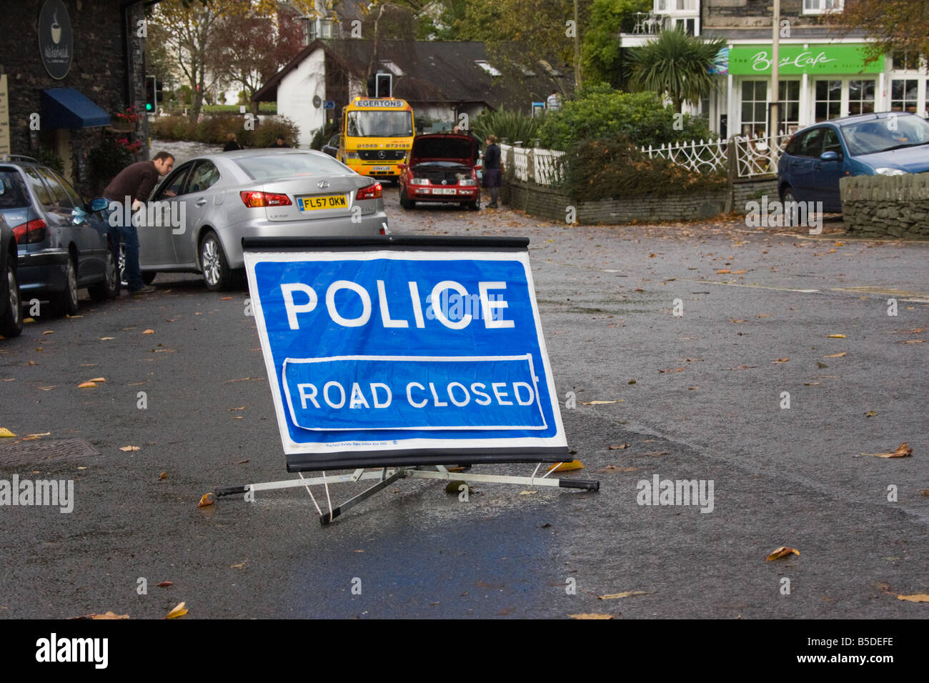 A 'police road closed' sign sits at the side of a flooded road in ...