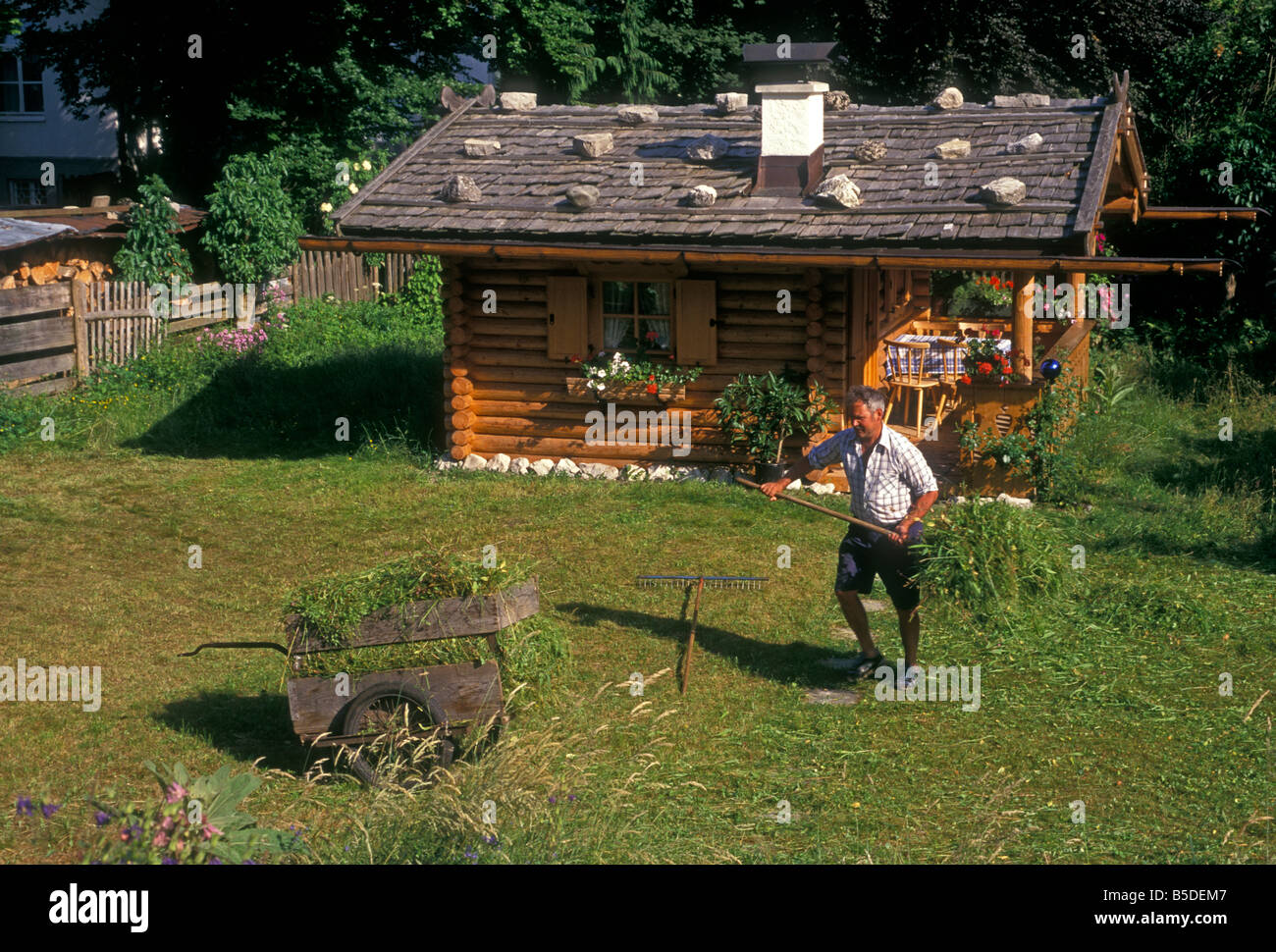 German Bavarian man raking yard town of Garmisch-Partenkirchen Bavaria ...