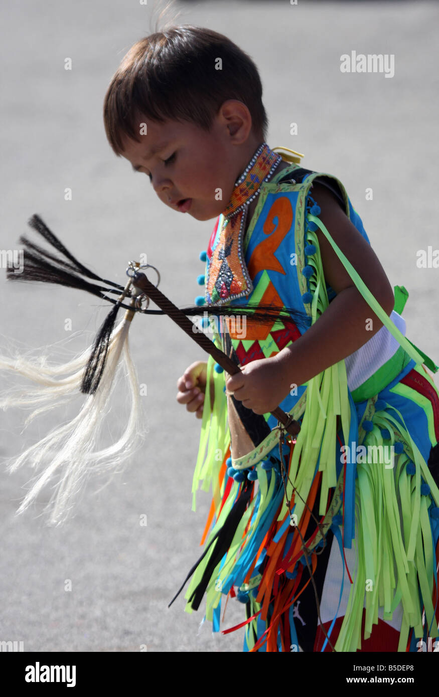A young Native American Indian boy dancing in a fancy outfit at a Pow ...