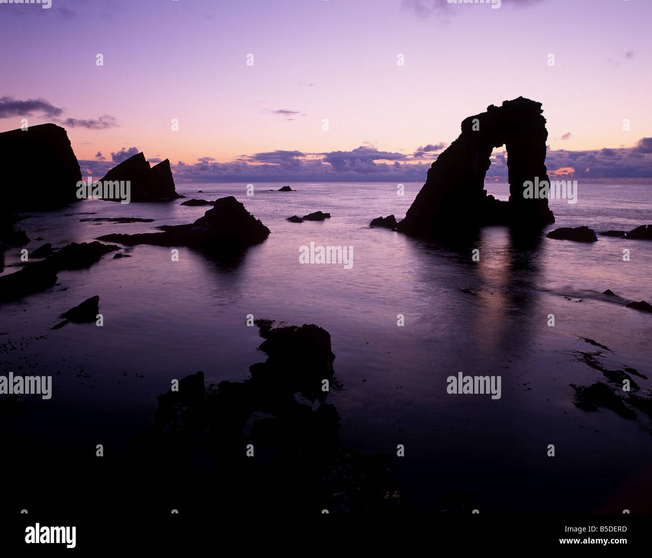 Gaada Stack natural arch, 45 m high, at sunset, Foula, Shetland Islands ...