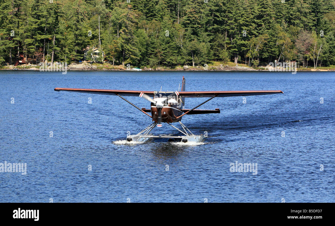 A single engine float plane taxing to the dock on Long Lake New York ...