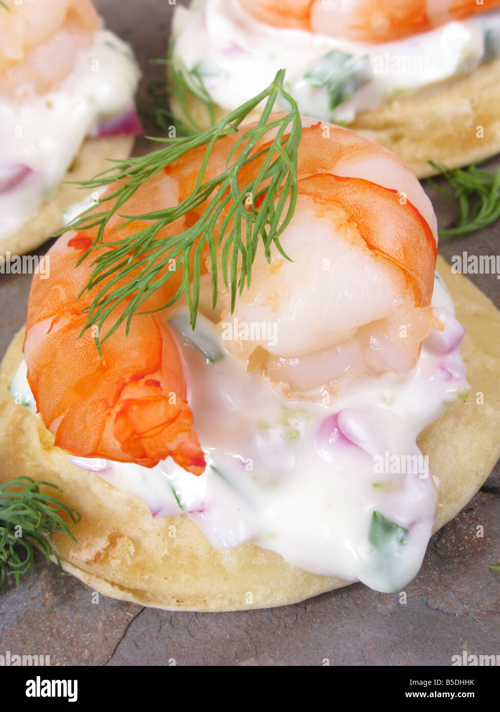 Tiger prawn on blini with soured cream and dill Stock Photo - Alamy