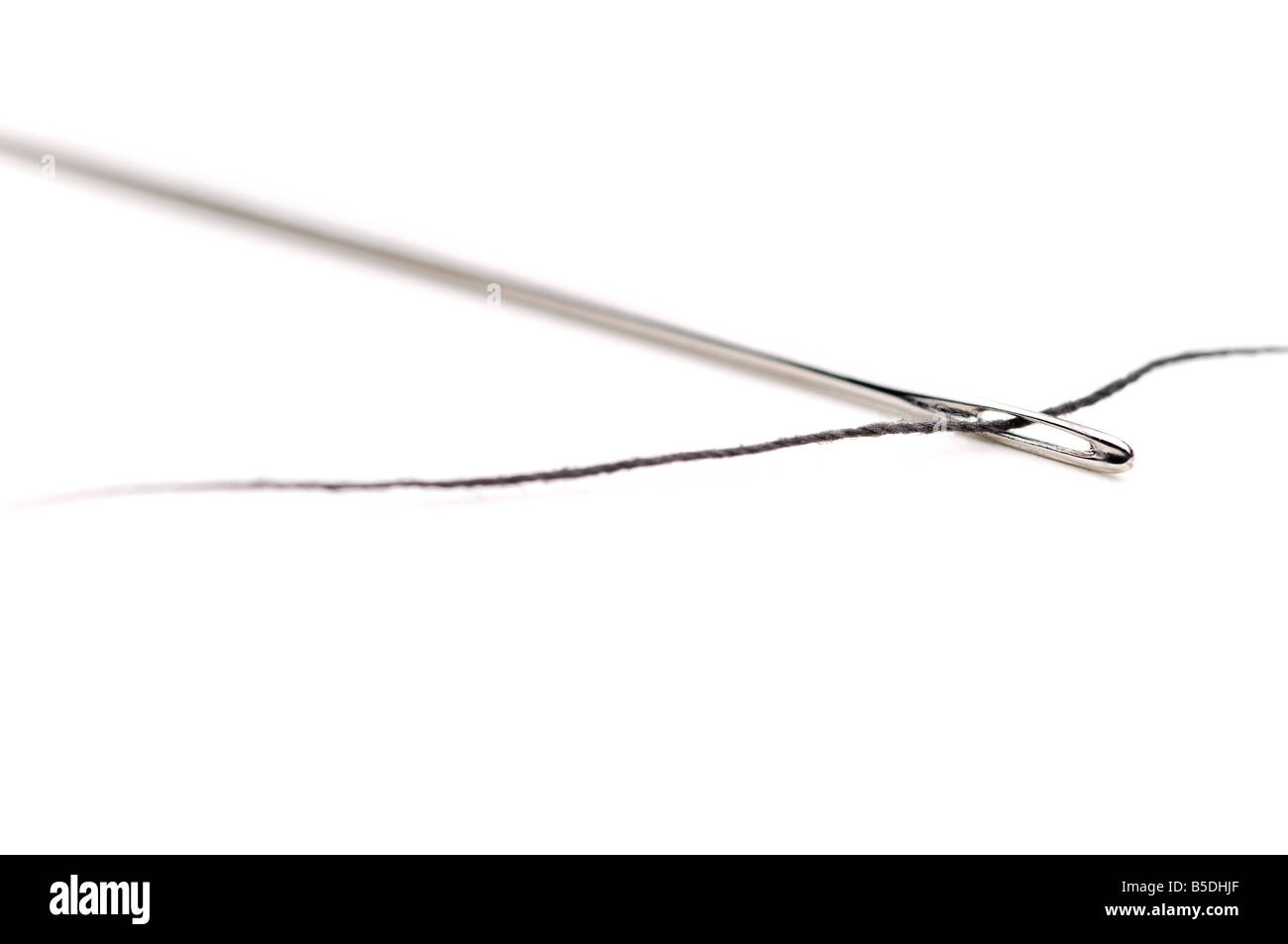 Macro of a needle and dark thread Stock Photo - Alamy