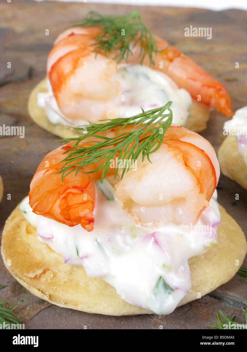 Tiger prawns on blinis with soured cream and dill Stock Photo - Alamy