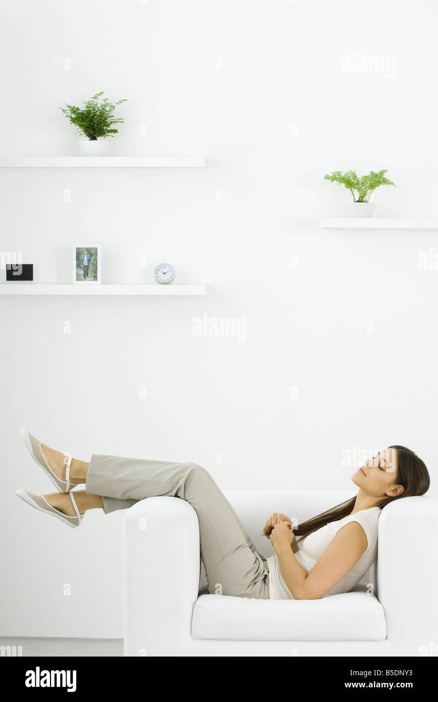 Woman reclining in armchair, side view Stock Photo - Alamy