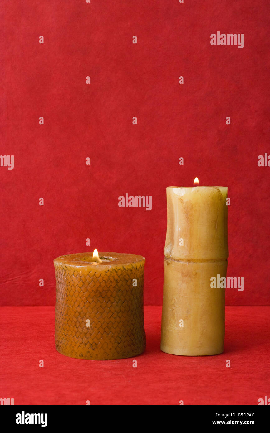 Two pillar candles, side by side, burning Stock Photo - Alamy