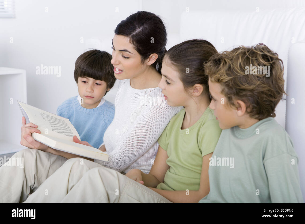 Woman reading story to her children Stock Photo - Alamy